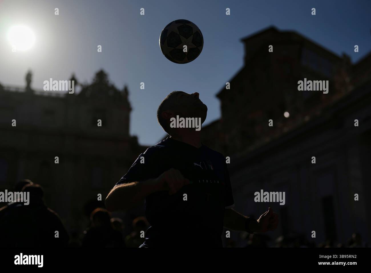 A man plays with a ball waiting for smoke to billow from the chimney of ...