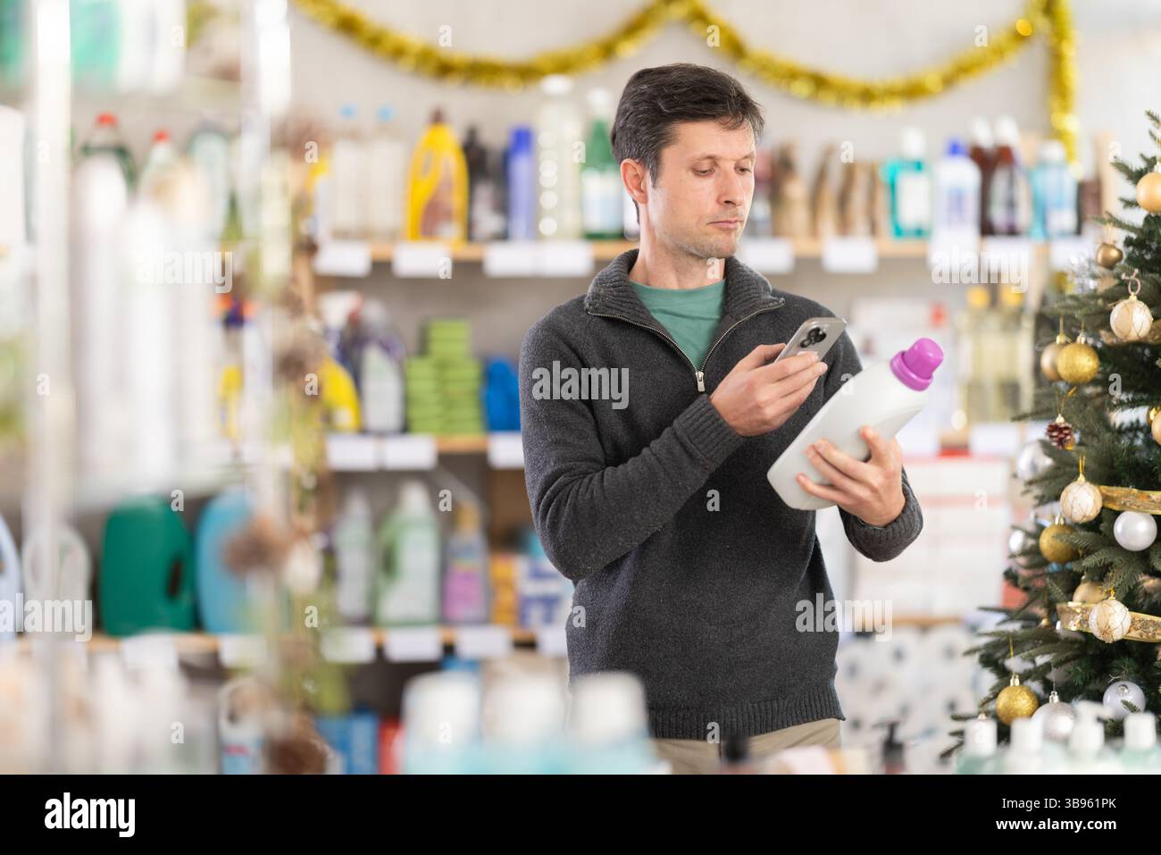 Adult man scanning qr code for detergent Stock Photo - Alamy