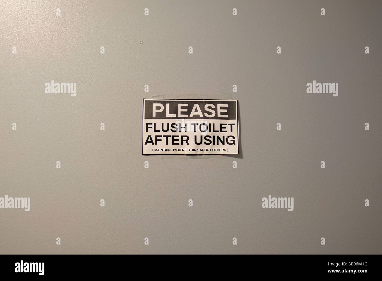 A printed "Please Flush Toilet After Using" paper sign on a public ...