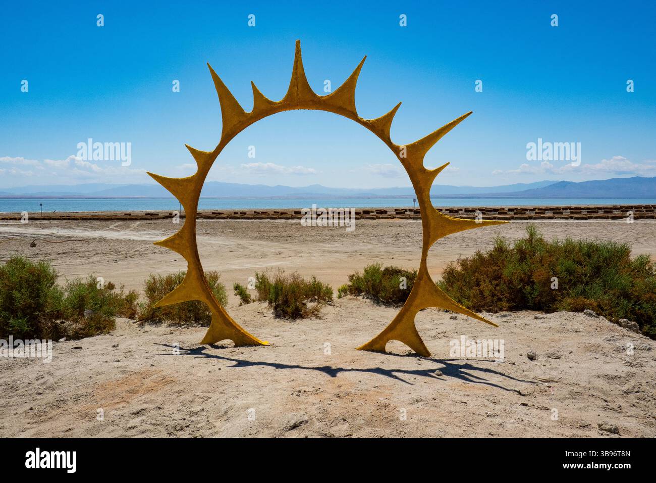 Large yellow metal sun sculpture on the beach in Bombay Beach ...