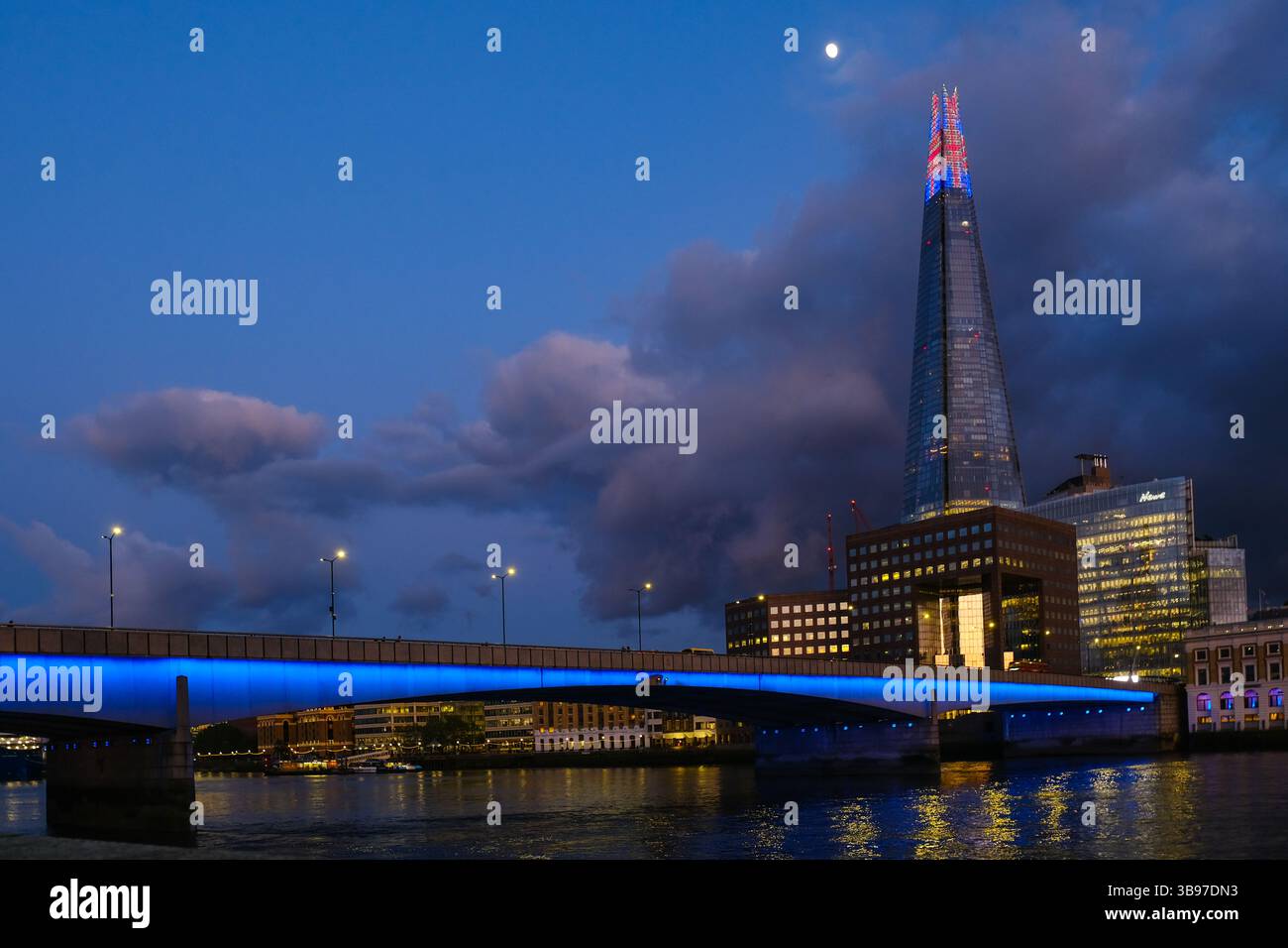 London, UK. 8th May, 2025. The tip of the Shard is lit up in red, white ...