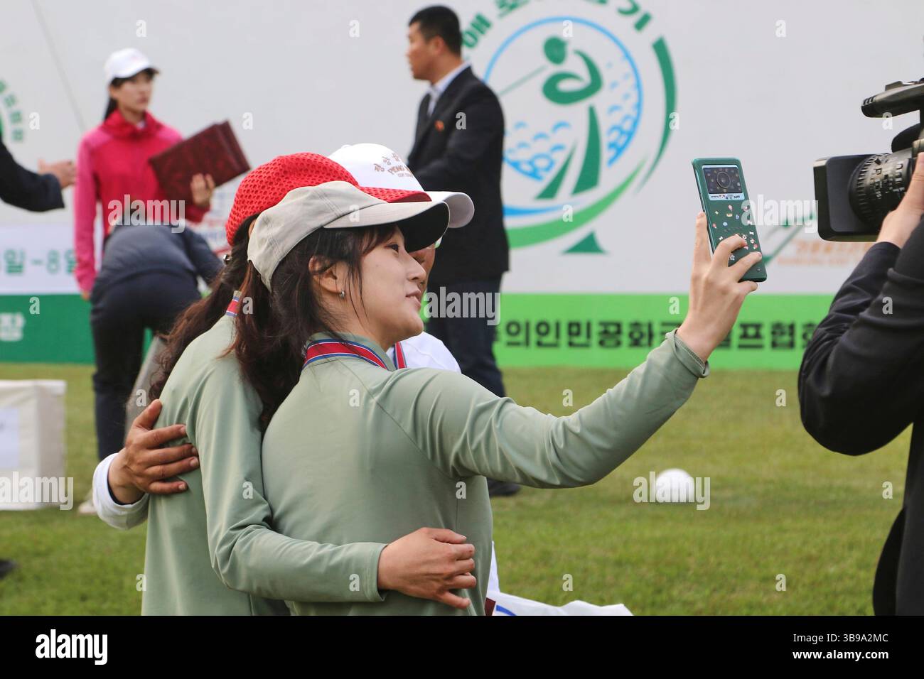 Participants take a selfie after winning in a spring golf fan contest ...