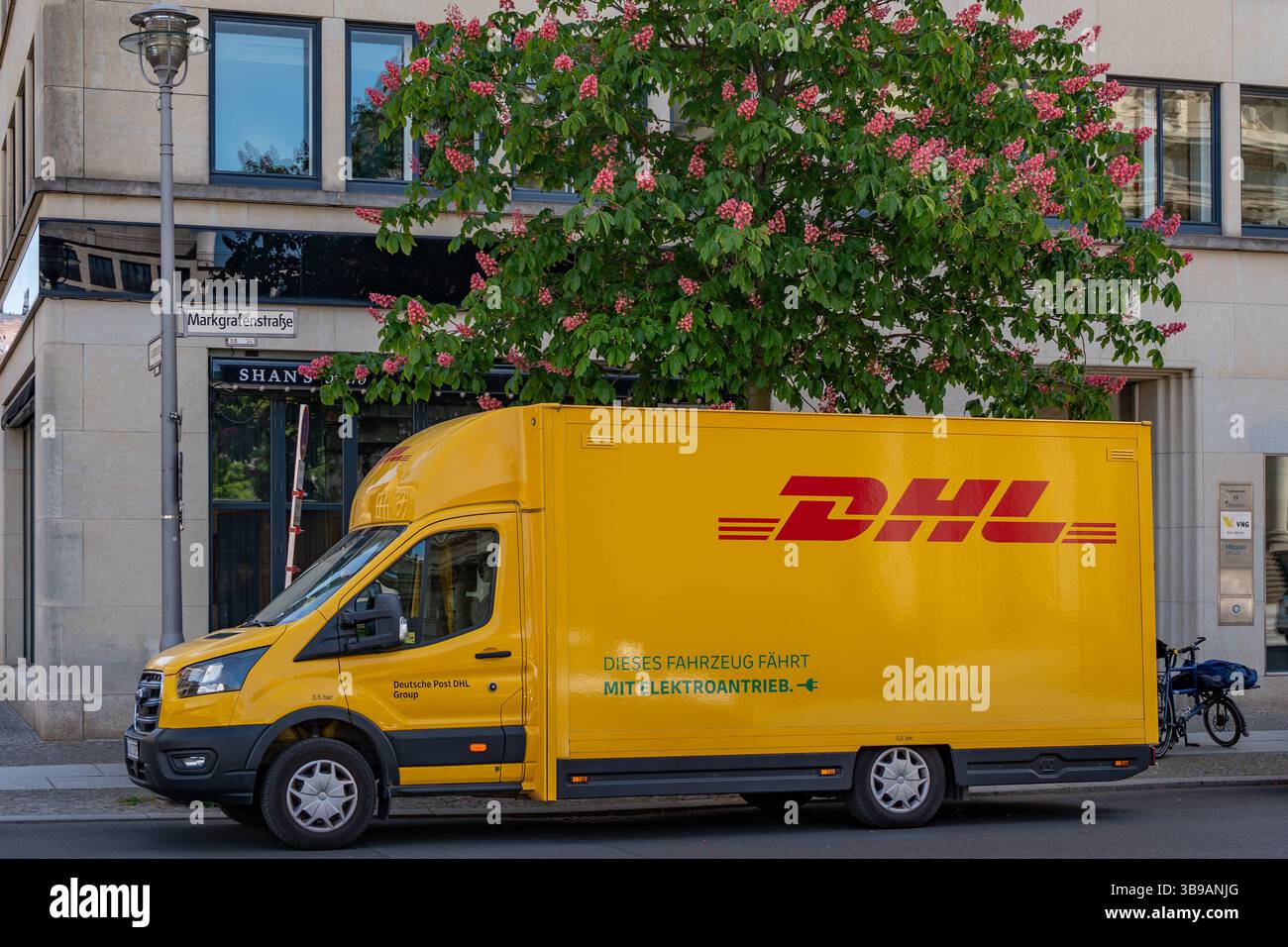 Germany Berlin May 7, 2025. Yellow car of the German post DHL. Electric ...