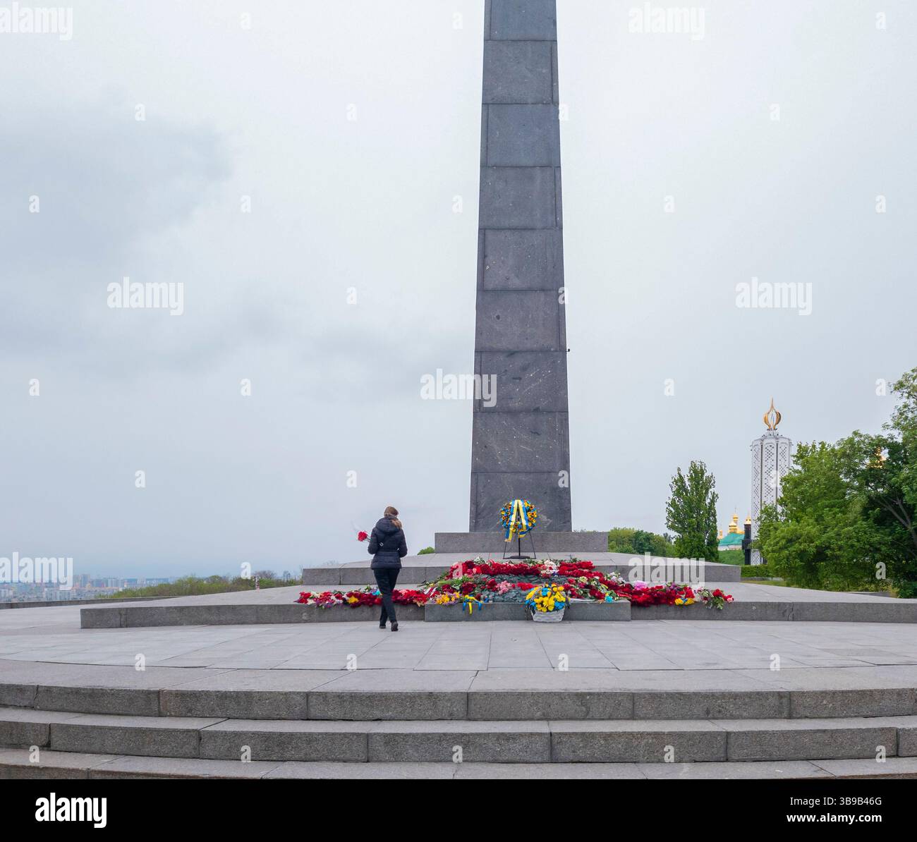 Kyiv, Ukraine - 9th May, 2025: Park of Eternal Glory. Woman brings ...