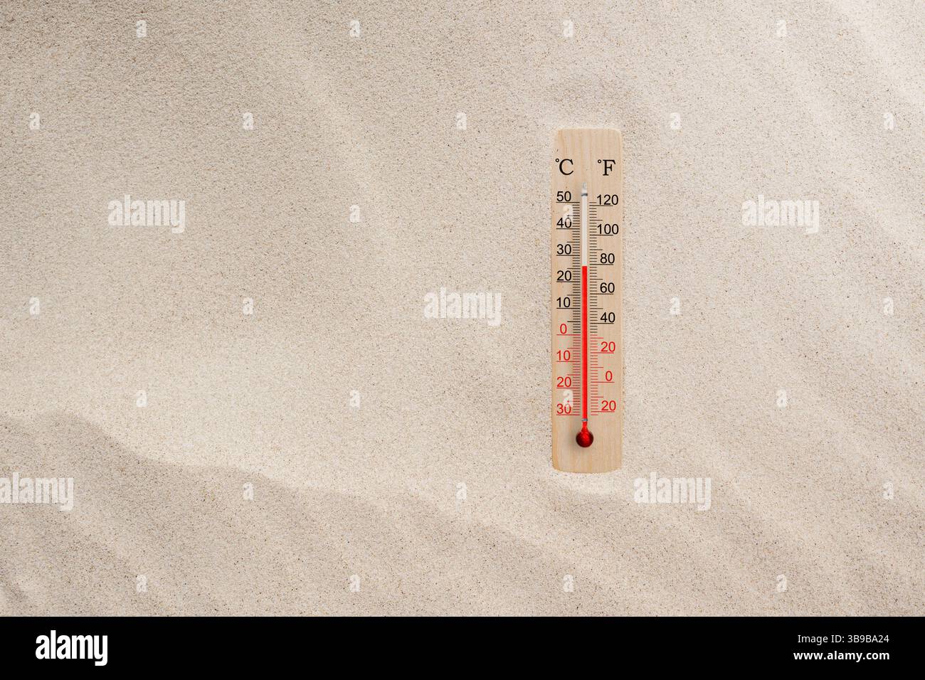 Wooden celsius and fahrenheit scale thermometer in the sand. Ambient ...