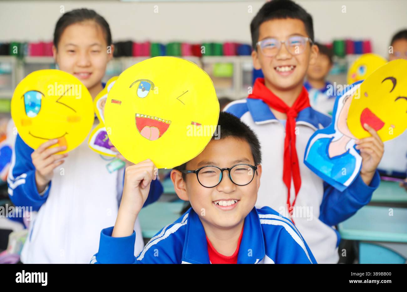Students draw pictures of smiley faces on the World Smile Day in ...