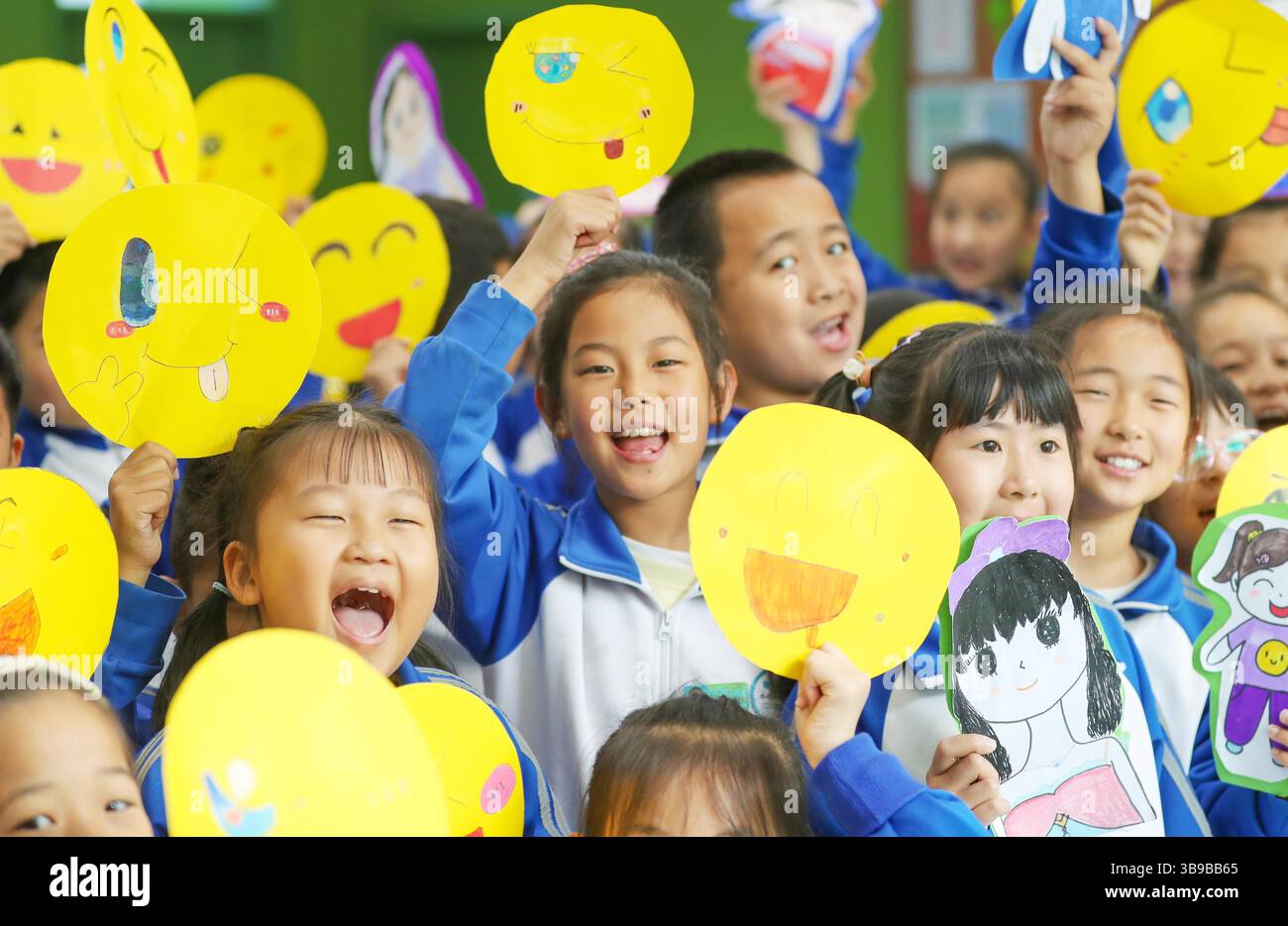 Students draw pictures of smiley faces on the World Smile Day in ...
