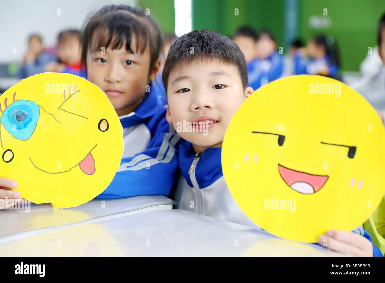 Students draw pictures of smiley faces on the World Smile Day in ...
