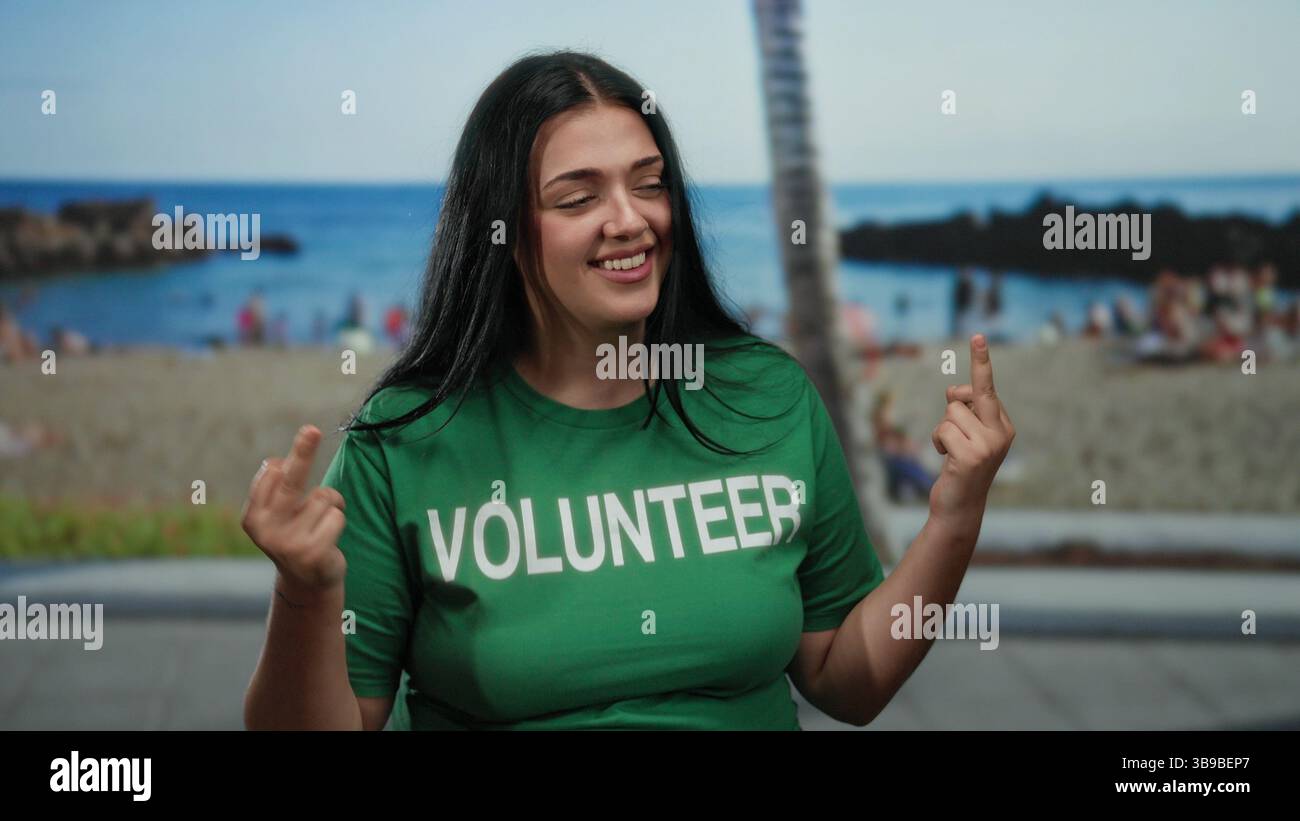 Woman in green volunteer shirt by seaside beach scene showing middle ...
