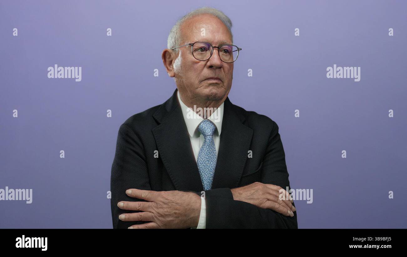 Senior man in business suit with glasses stands confidently against a ...