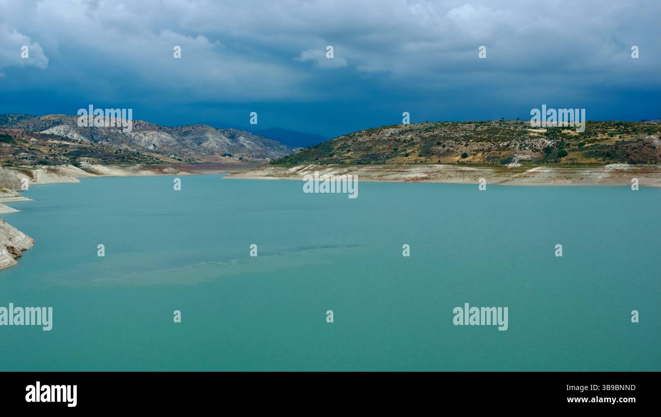 A peaceful lake surrounded by arid hills, reflecting the serene beauty ...