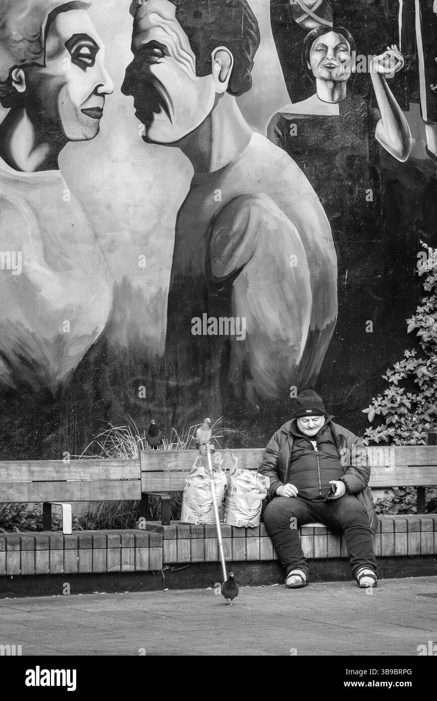 London, England - 28th April 2025: A homeless man on a park bench with ...