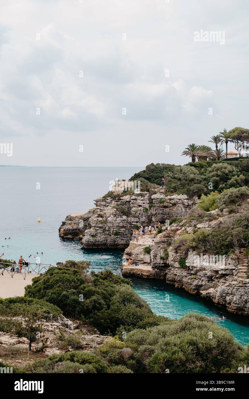 Swimmers and rocky cliffs at Cala en Brut, Menorca Stock Photo - Alamy