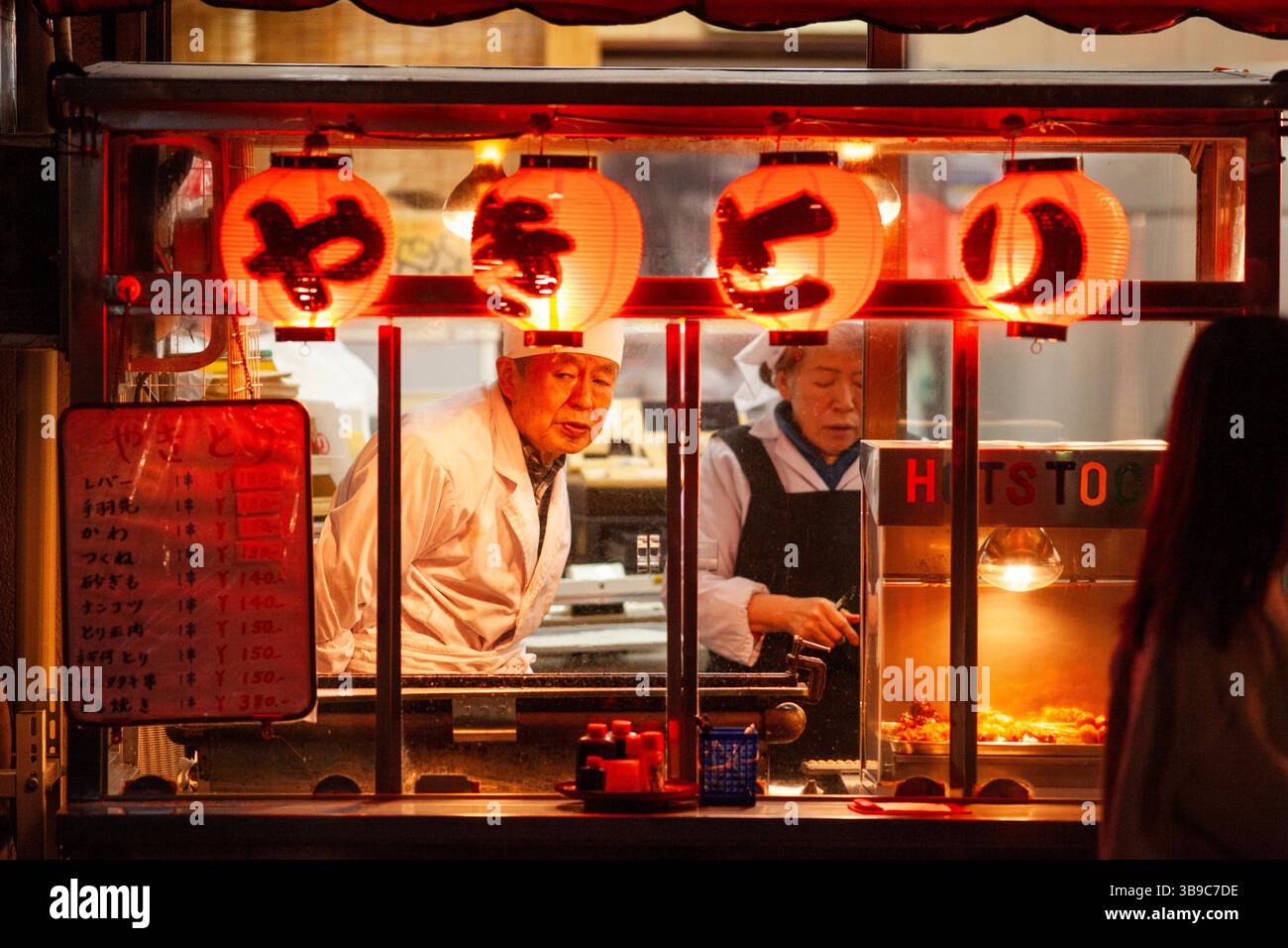Japanese man looks out from food counter window at night Stock Photo ...