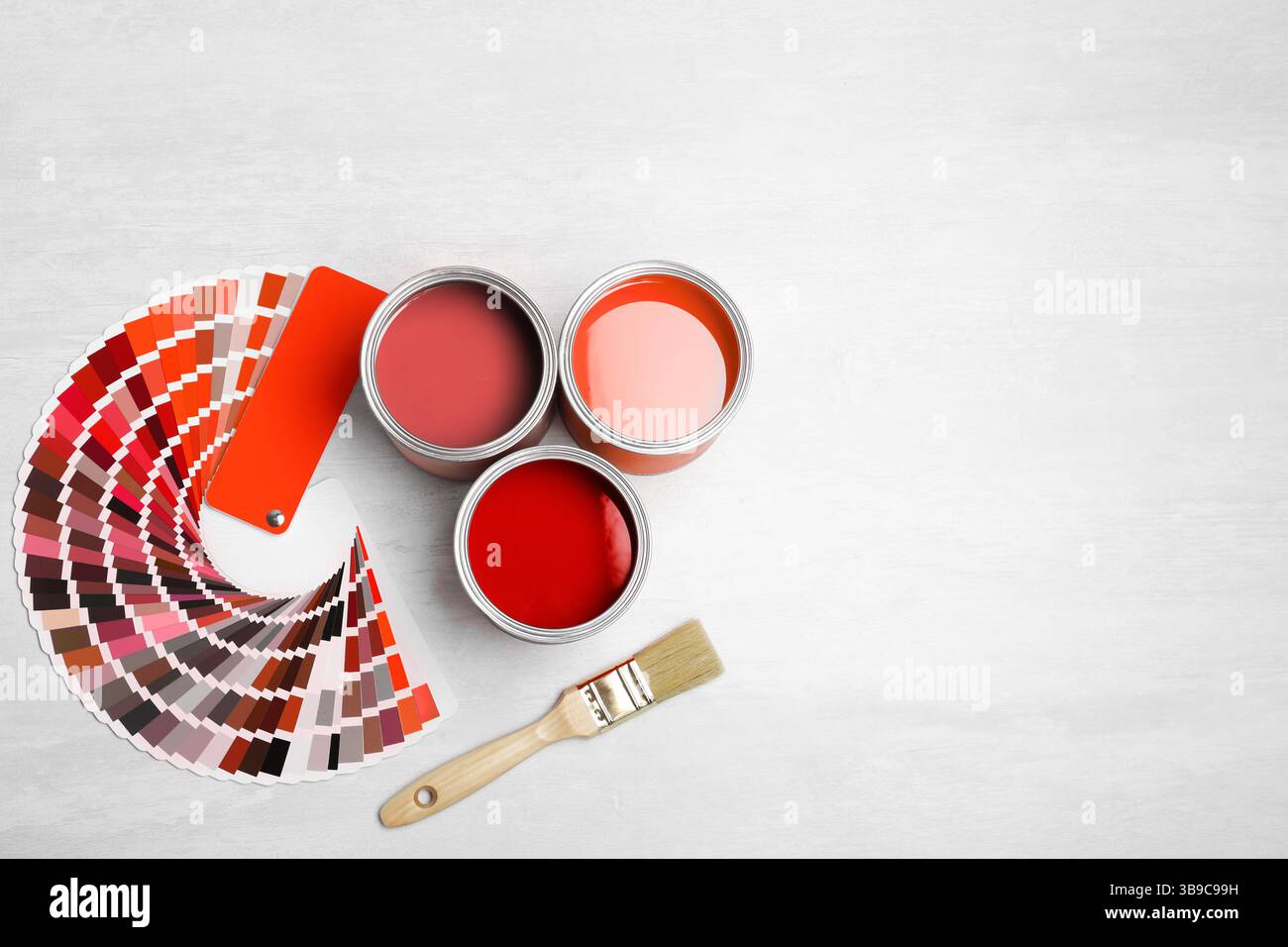 Cans with paint in shades of red, brush and color palette on white ...