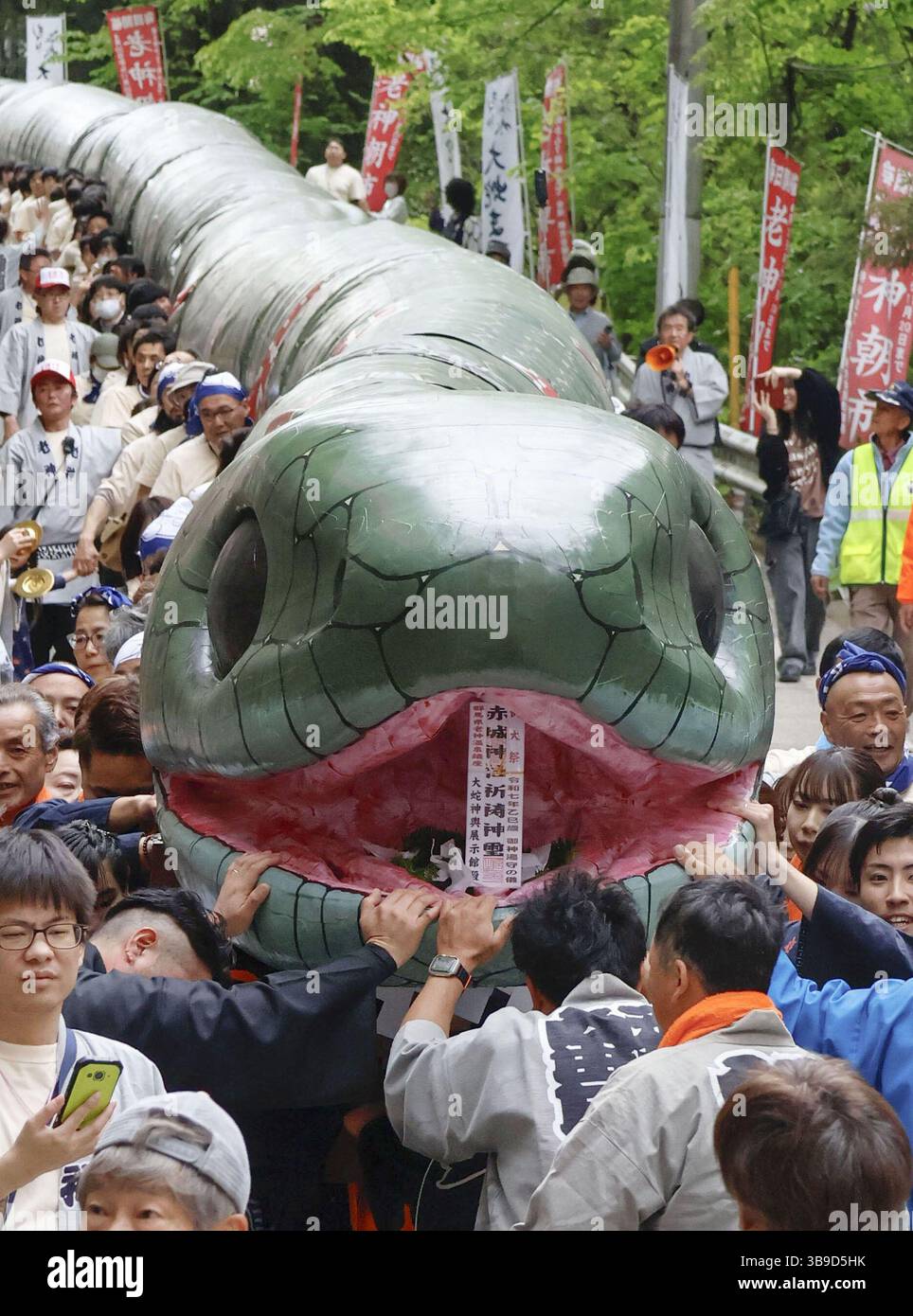 About 300 high school students carry a snake-shaped float during a ...