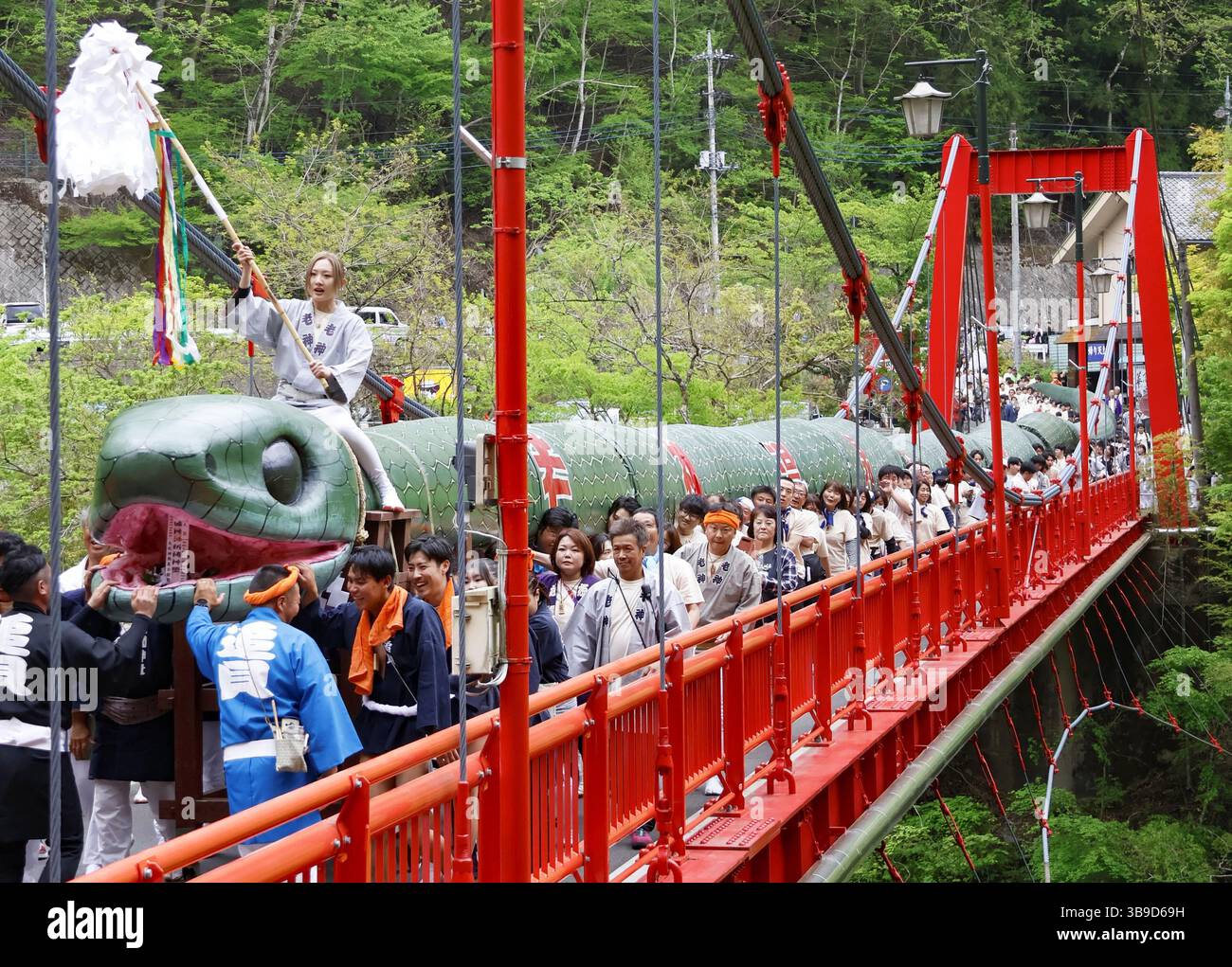 About 300 high school students carry a snake-shaped float during a ...