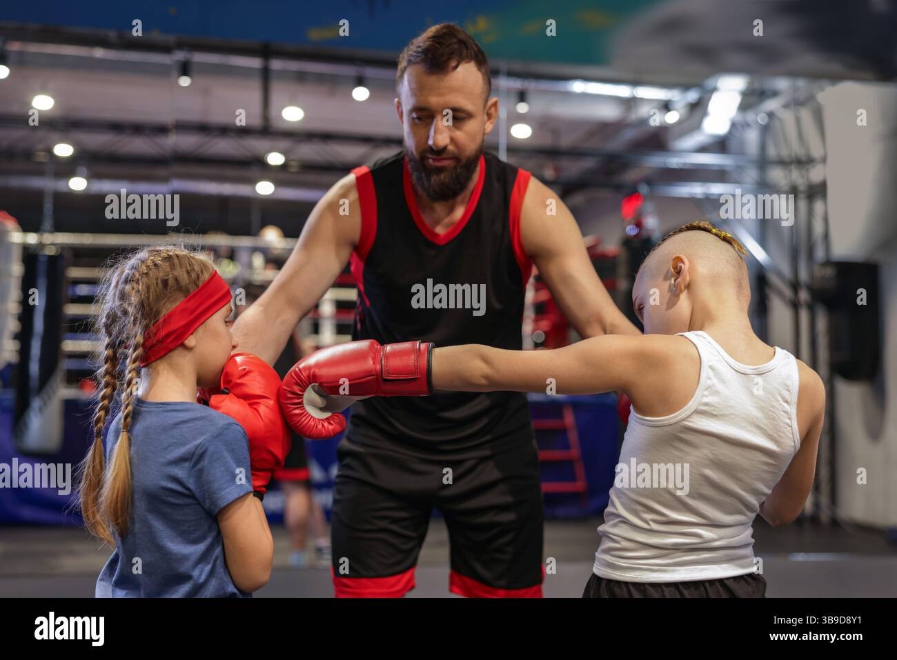 Boxing coach training children in sport center Stock Photo - Alamy