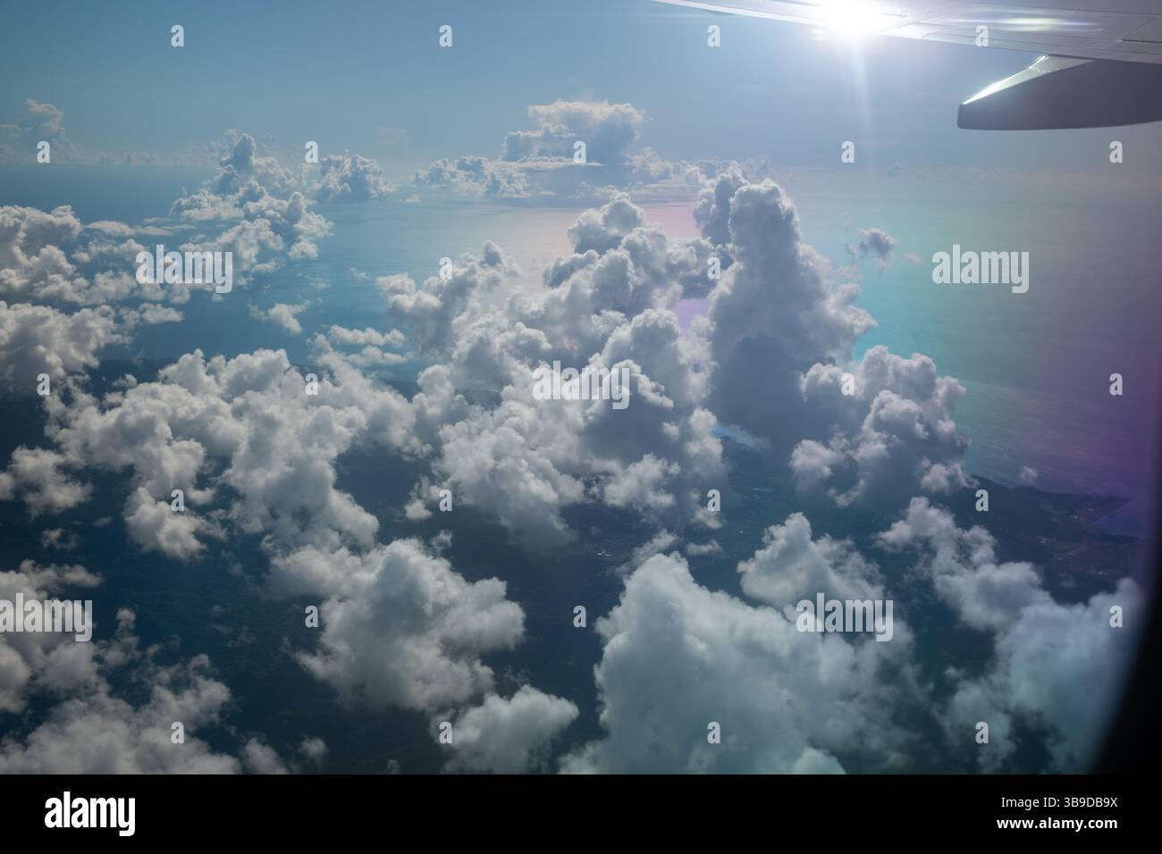 Above the clouds from airplane window. Beautiful view flying in a plane over the Caribbean ...