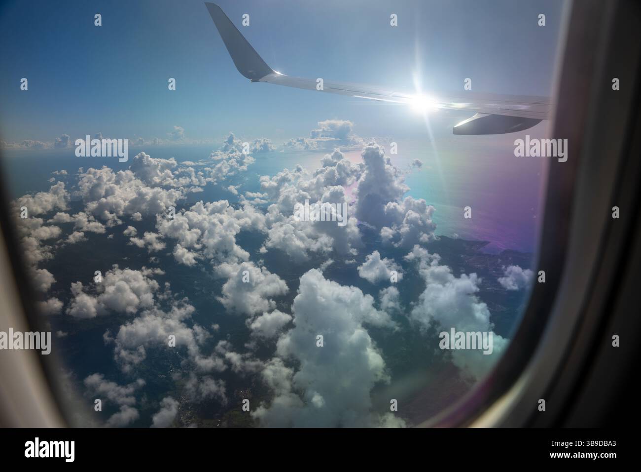 Above the clouds from airplane window. Beautiful view flying in a plane over the Caribbean ...