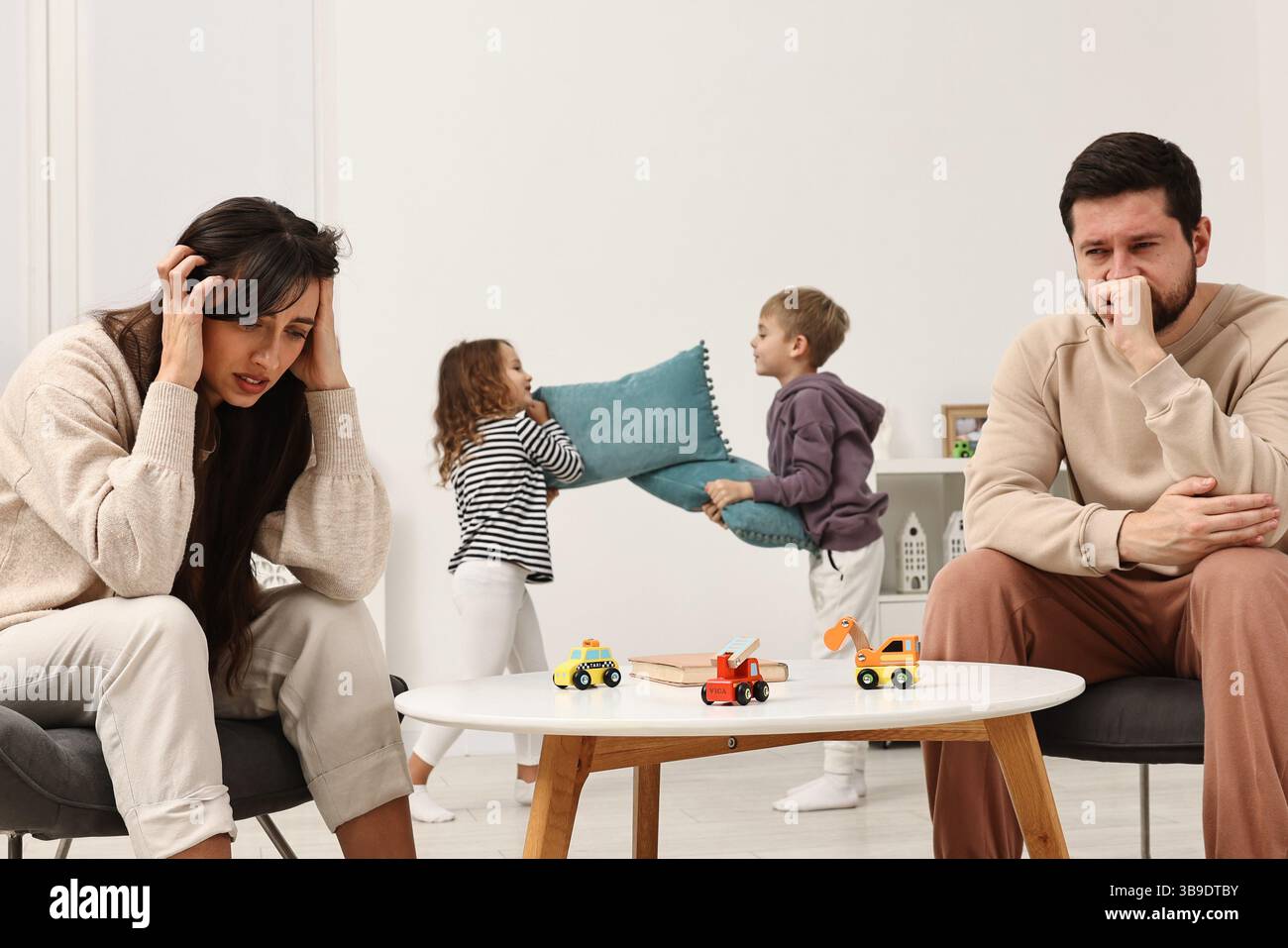 Overwhelmed parents and their naughty children at home Stock Photo - Alamy