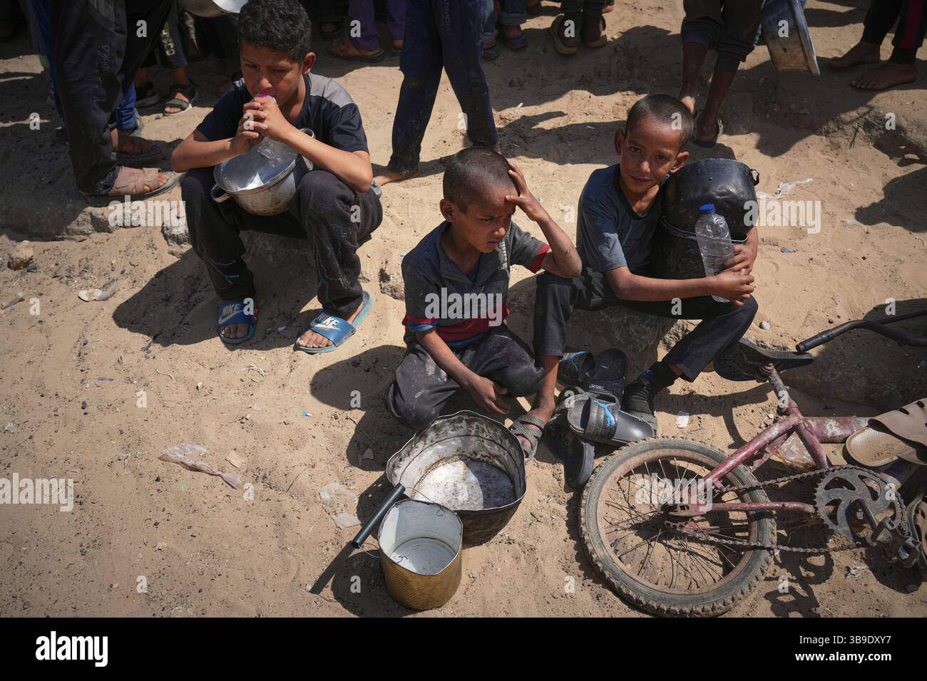 Palestinian children wait to get donated food at a community kitchen in ...