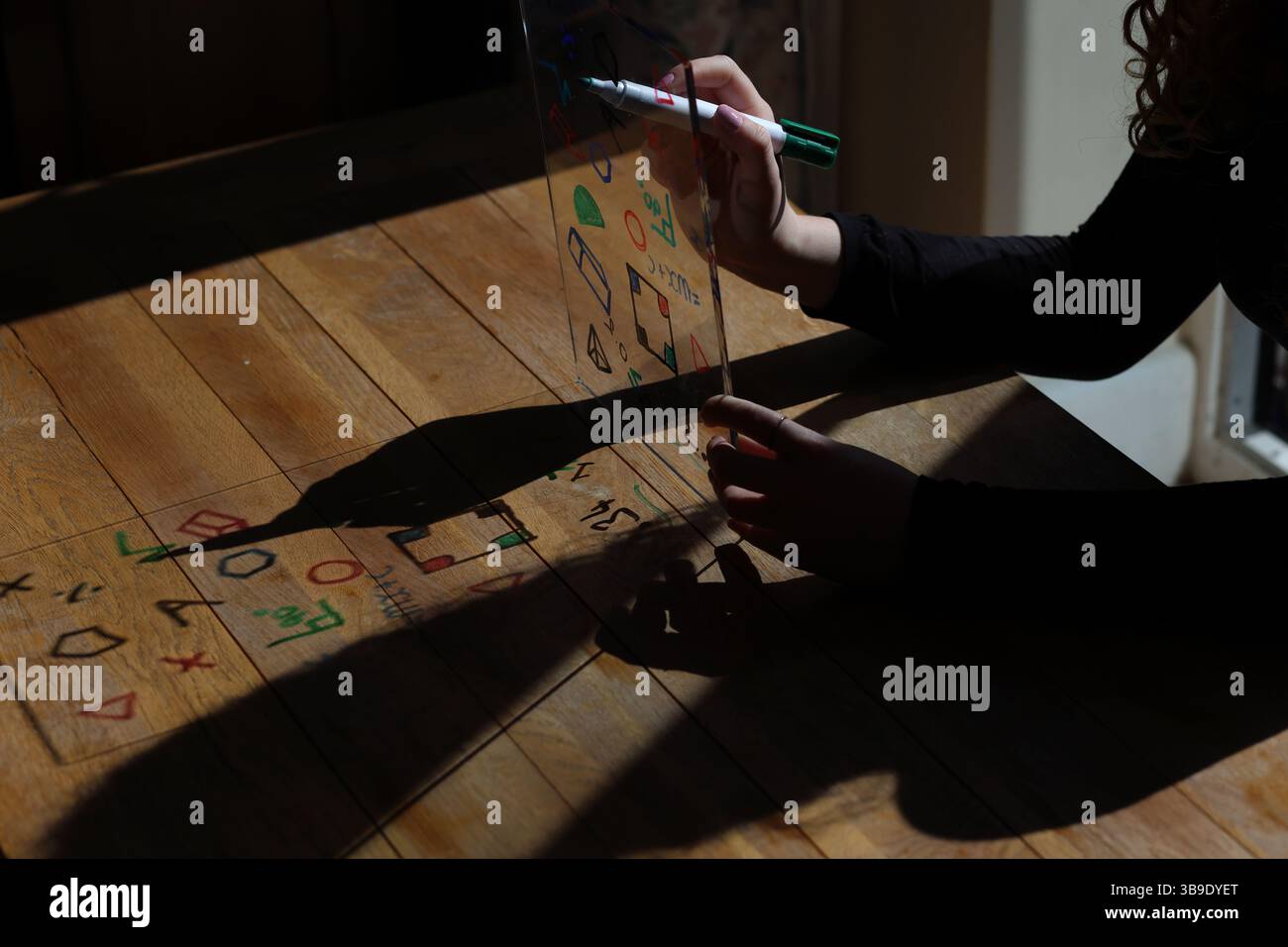 Teenage girl writing drawing maths symbols and shapes on tranparent ...