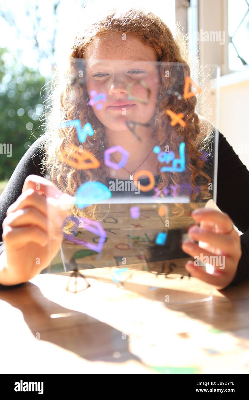 Teenage girl writing drawing maths symbols and shapes on tranparent ...