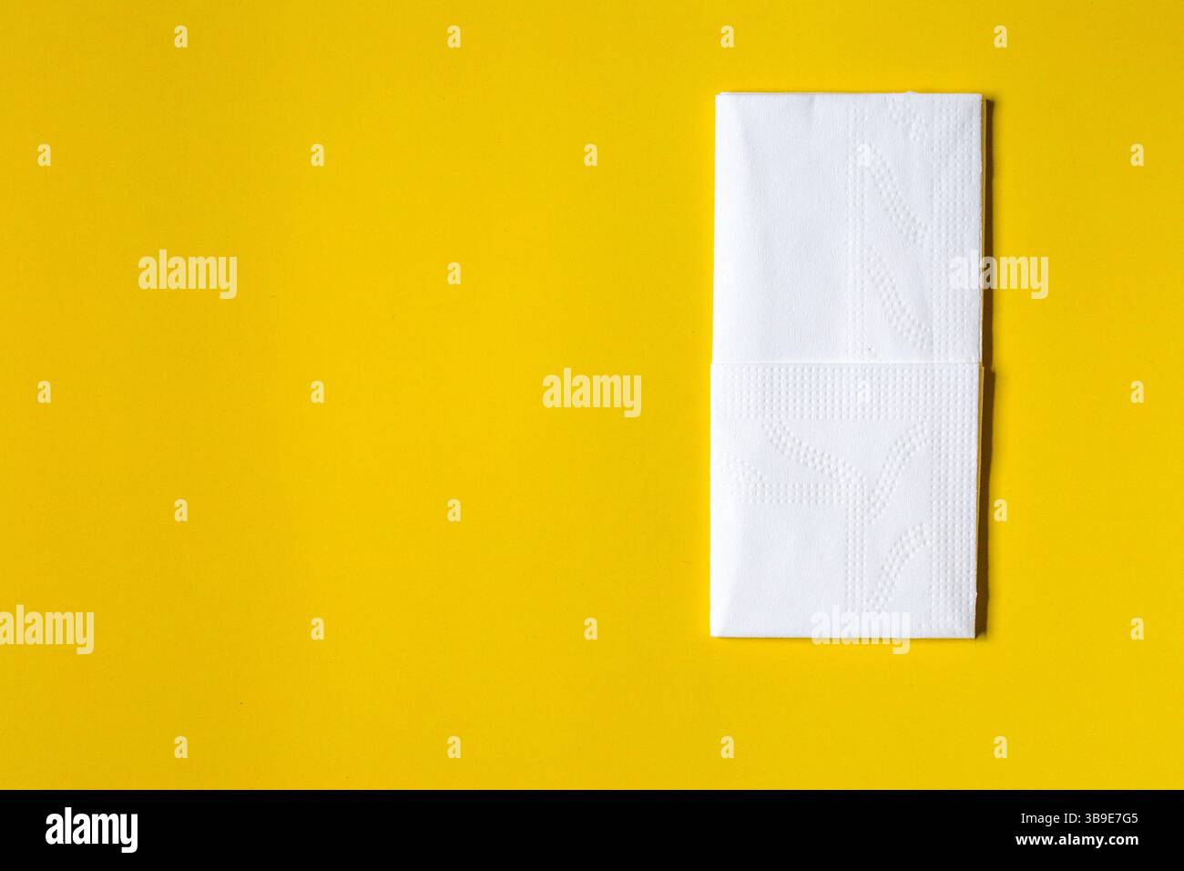 A neatly arranged stack of white dry tissues on a plain background. The ...