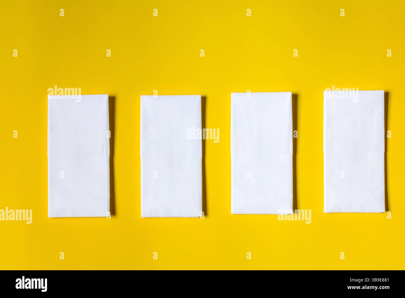 A neatly arranged stack of white dry tissues on a plain background. The ...