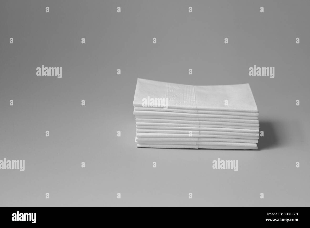 A neatly arranged stack of white dry tissues on a plain background. The ...