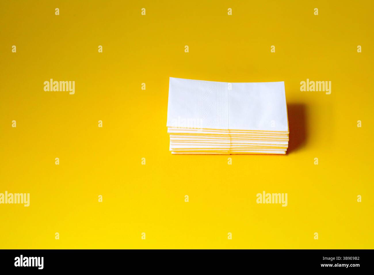 A neatly arranged stack of white dry tissues on a plain background. The ...