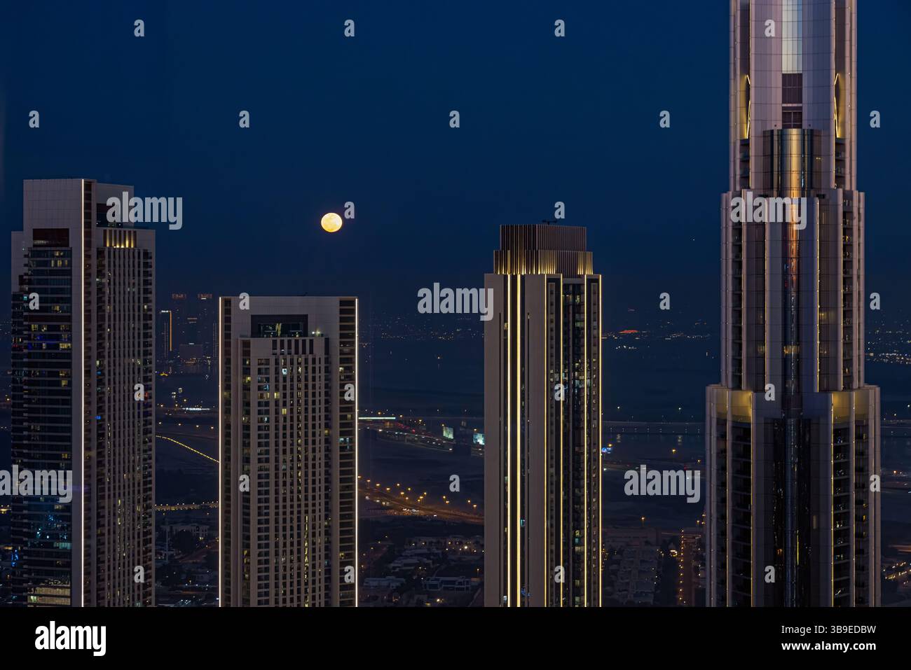Full moon behind illuminated buildings hi-res stock photography and ...
