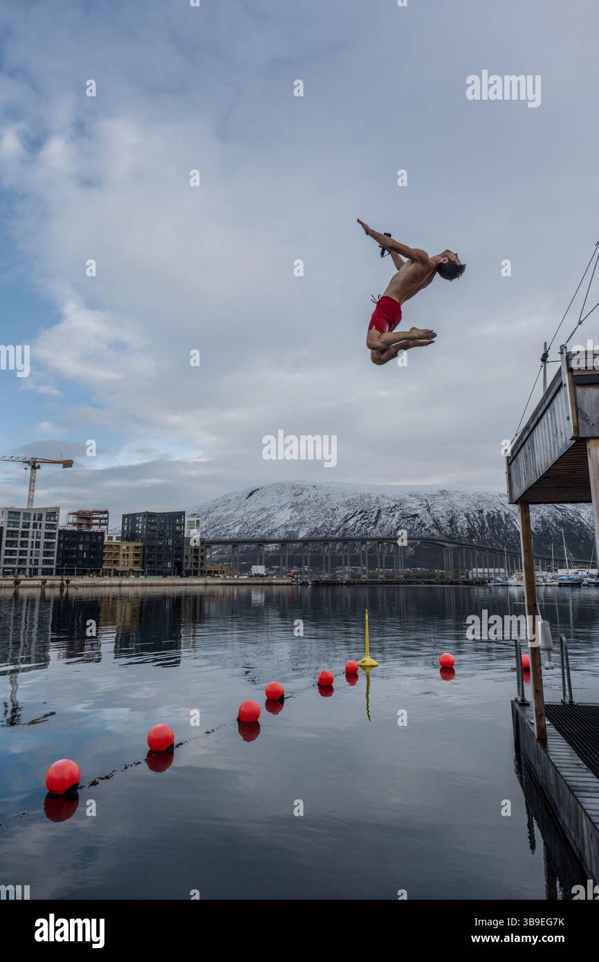 Man jumping off floating sauna dock into Arctic Ocean in Tromso Harbor ...