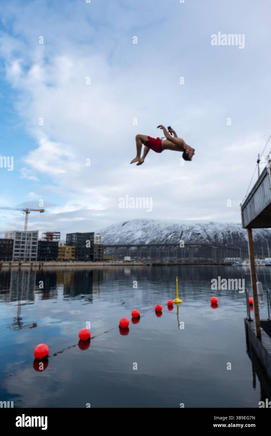 Man jumping off floating sauna dock into Arctic Ocean in Tromso Harbor ...