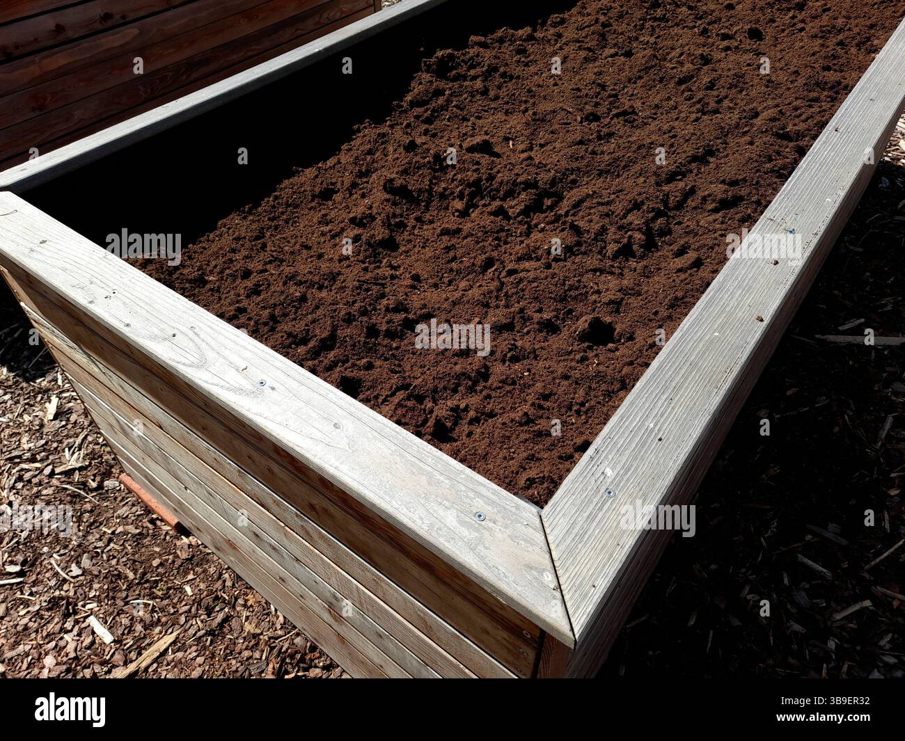 Wooden raised bed filled with fresh garden soil Stock Photo - Alamy