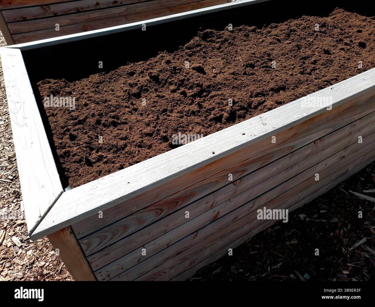 Wooden raised bed filled with fresh garden soil Stock Photo - Alamy