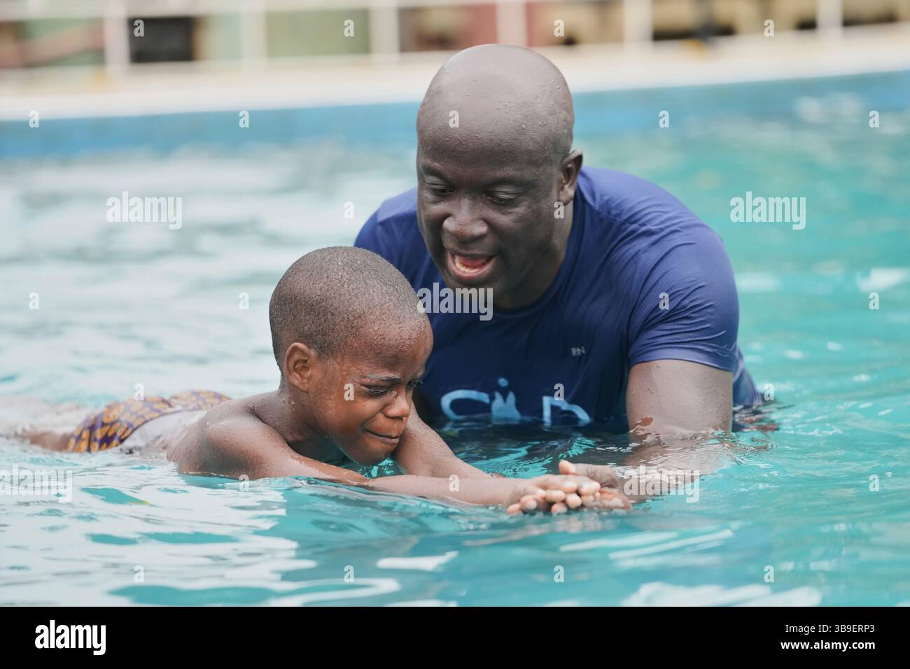 Swimming coach Emeka Chuks Nnadi teaches a young, disabled student to ...