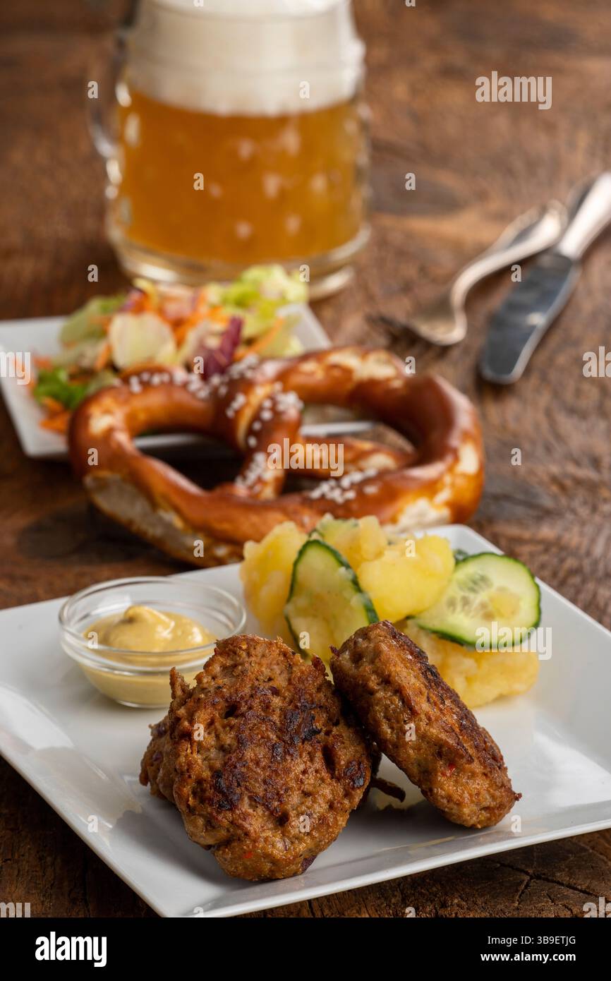 Bavarian meat patty with potato salad Stock Photo - Alamy