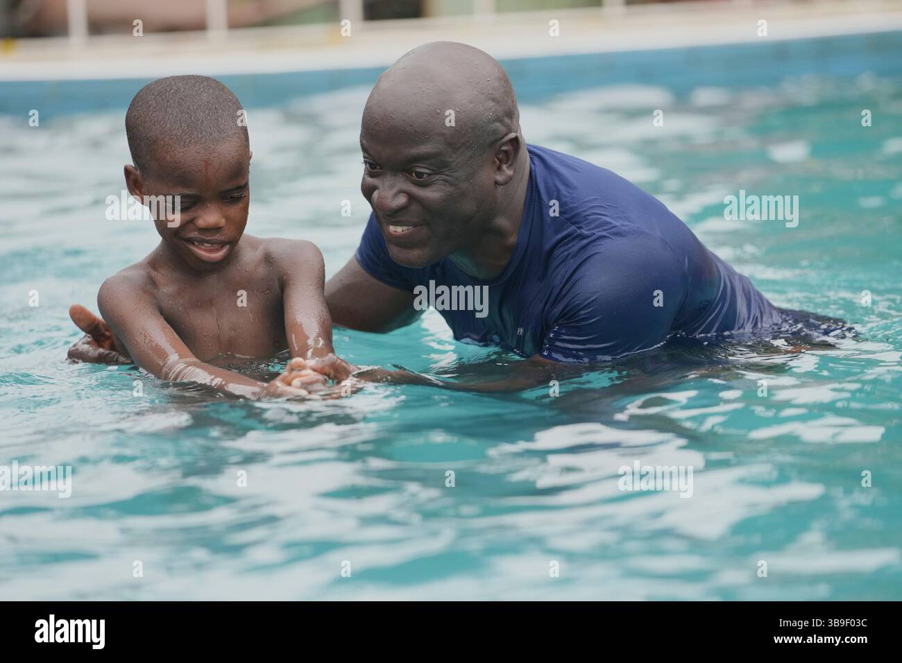 Swimming coach Emeka Chuks Nnadi teaches a young, disabled student to ...