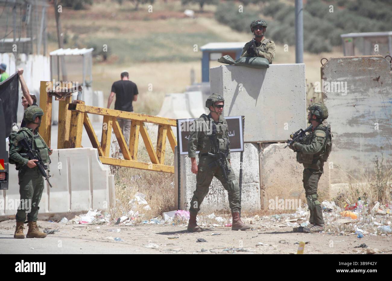 Israeli soldiers take up positions at the Beit Furik checkpoint while ...