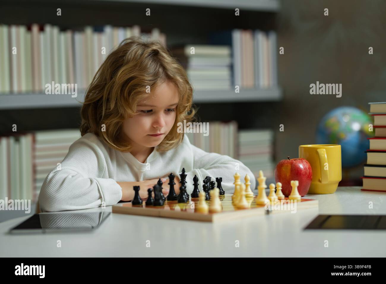 Kids early development. Boy kid playing chess at home. Chess school ...