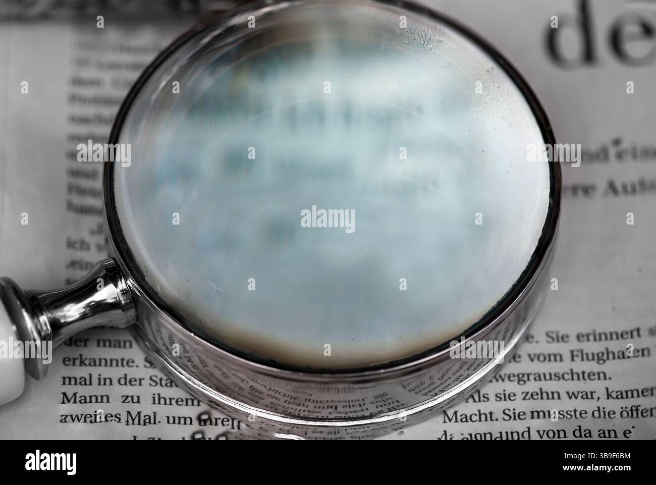 A magnifying glass, a reading aid lies on an old newspaper Stock Photo ...