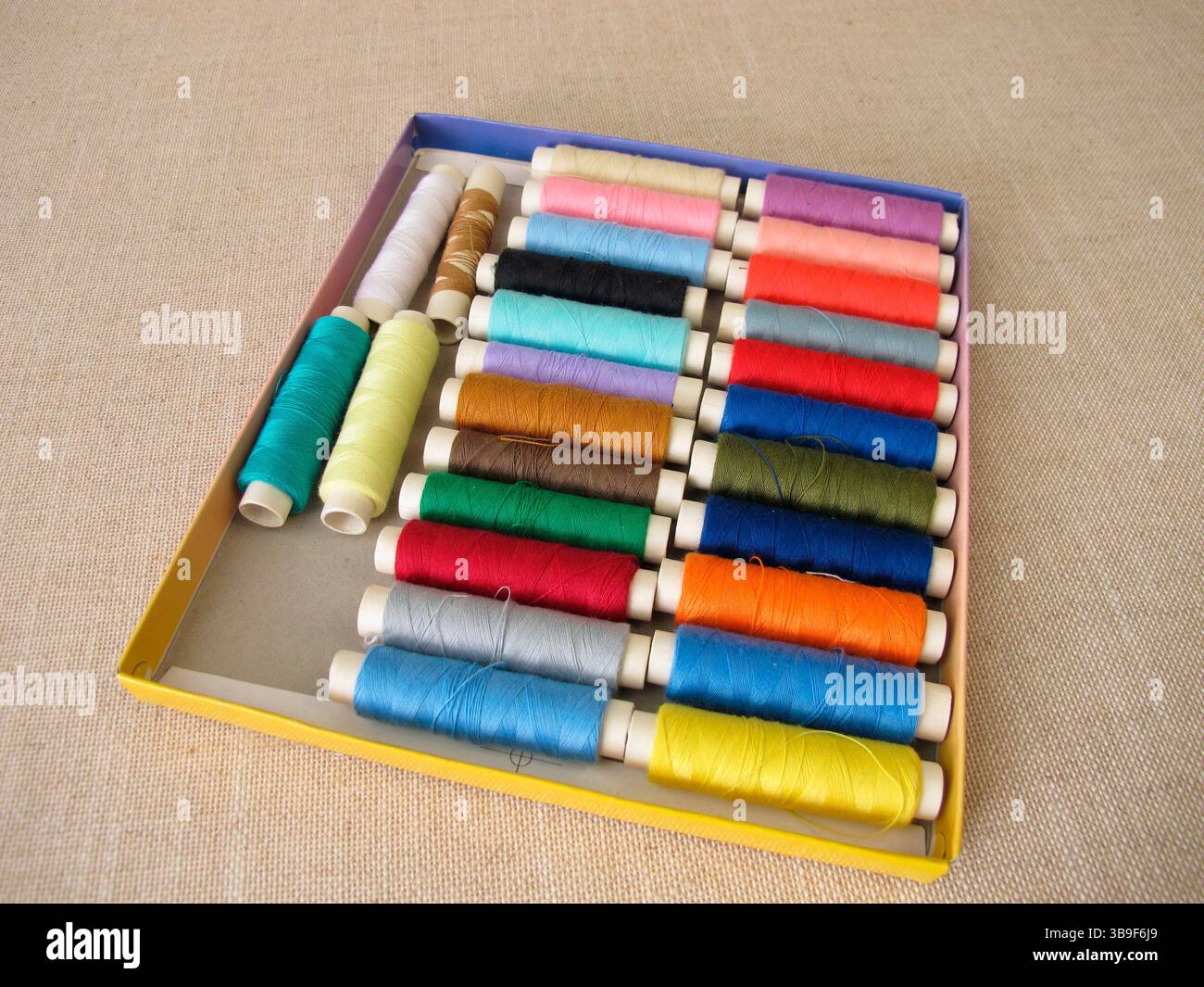 Sewing thread in different colours in a box Stock Photo - Alamy