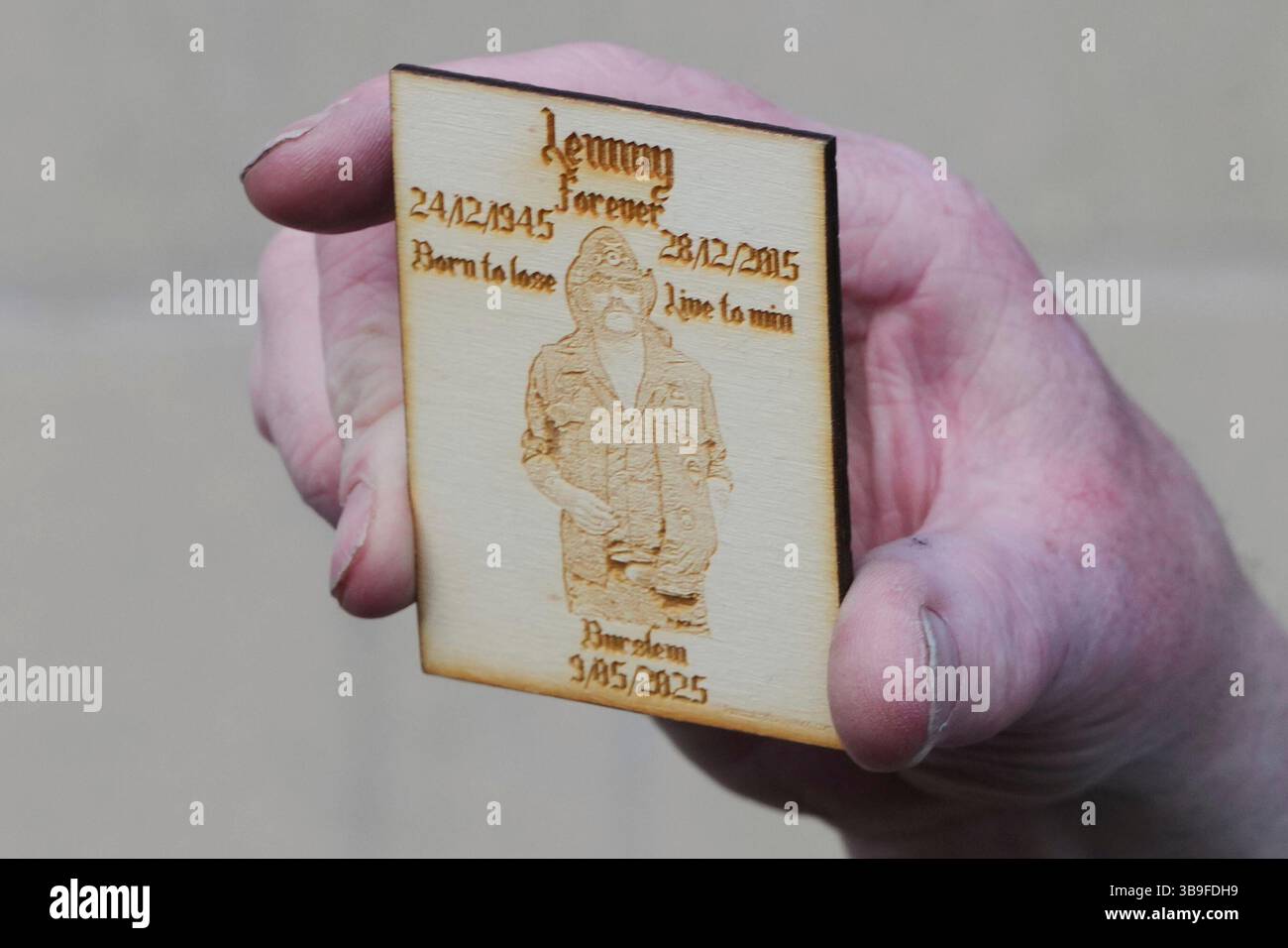 A man is holding a plaque that will be placed inside a statue to commemorate Lemmy Kilmister the ...