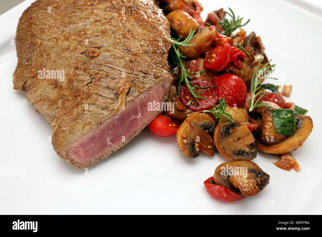 Veal rump on tomato mushroom vegetables Stock Photo - Alamy