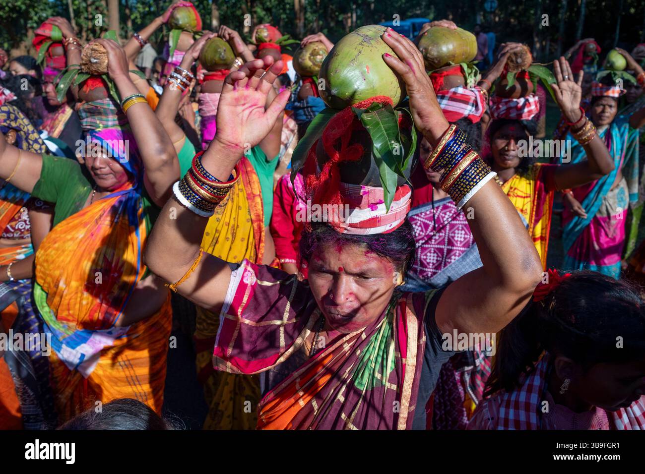 With faces powdered and carrying coconuts on their heads, women ...