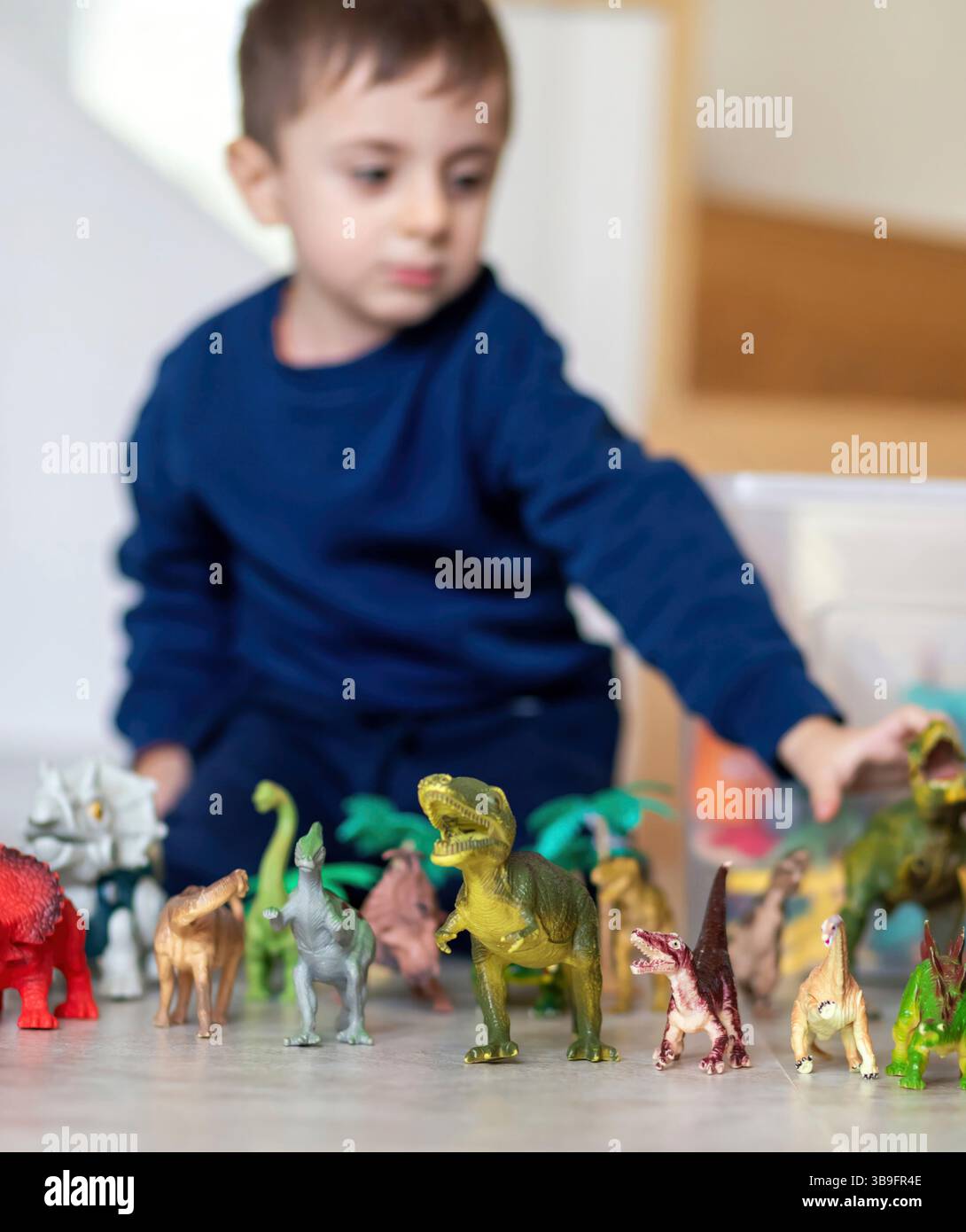 Blurred child playing with dinosaur toys in his room hi-res stock photography and images - Alamy