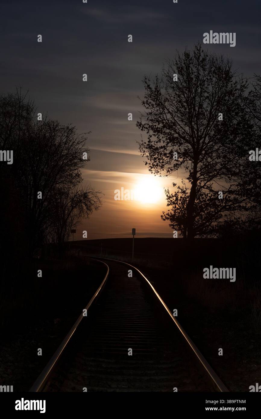 Rising full moon over a single-track railroad line Stock Photo - Alamy