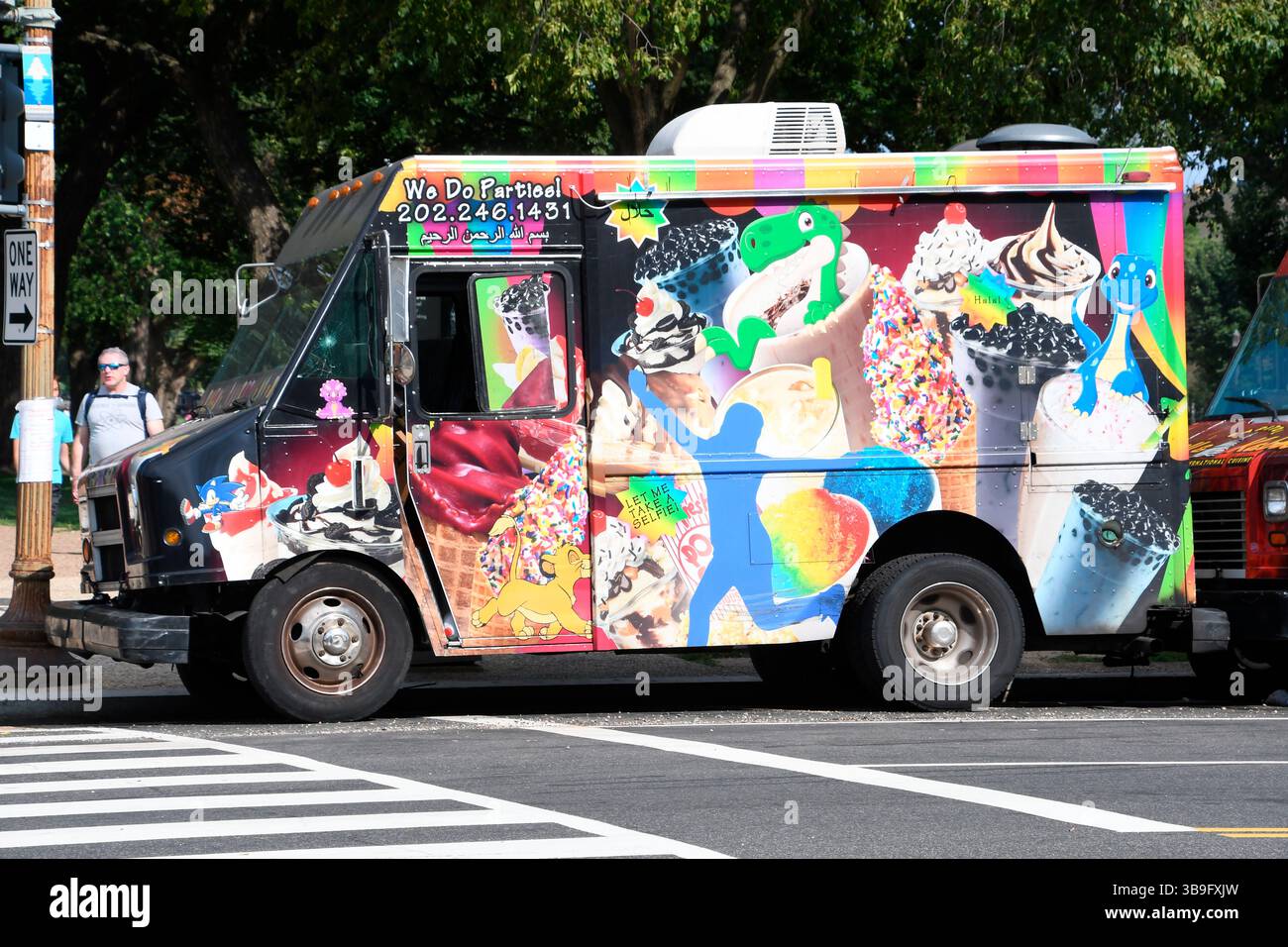 Colorfully decorated food truck at the roadside next to crosswalk hi ...